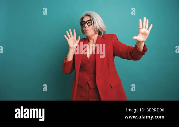 Stylish and successful senior woman with grey hair and glasses dancing ...