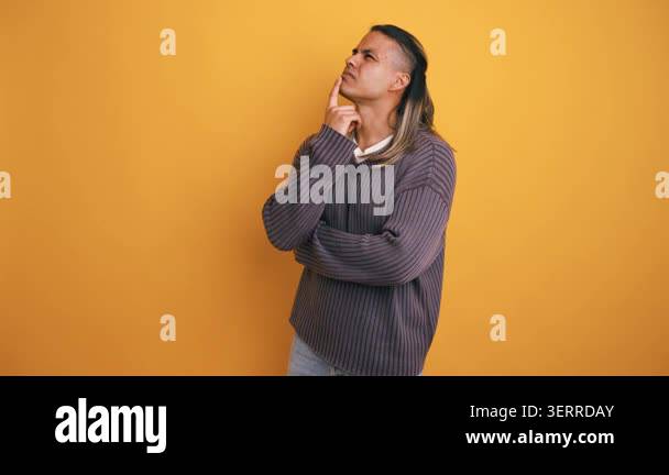 Young pensive man thinking about a problem. He has a great idea and ...