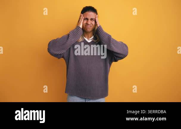 Unwell man with long hair touching his temples and chest. He is ...