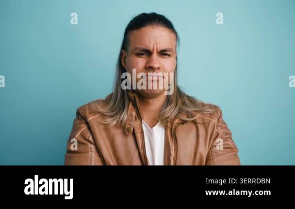 Upset Latino man with long hair expressing disapproval and disgust ...