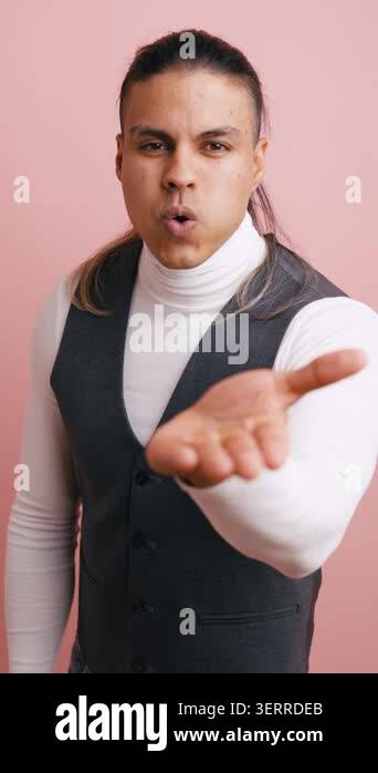 Affectionate long haired man sending a kiss and showing a heart sign ...