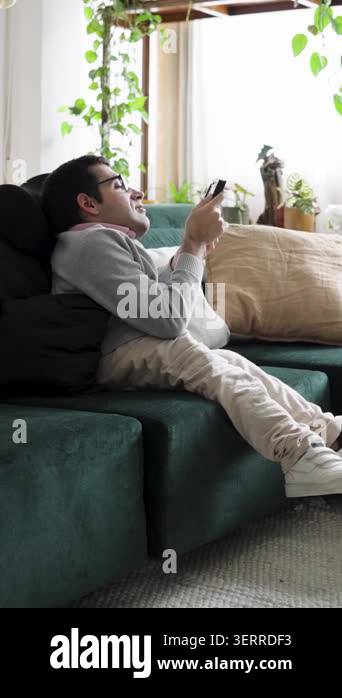 Young man with a physical difference sitting comfortably on the sofa ...