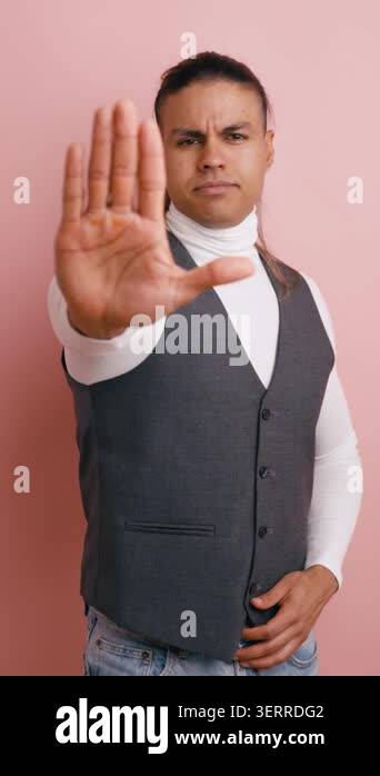 Dissatisfied young man showing a stop gesture with his palm and then ...