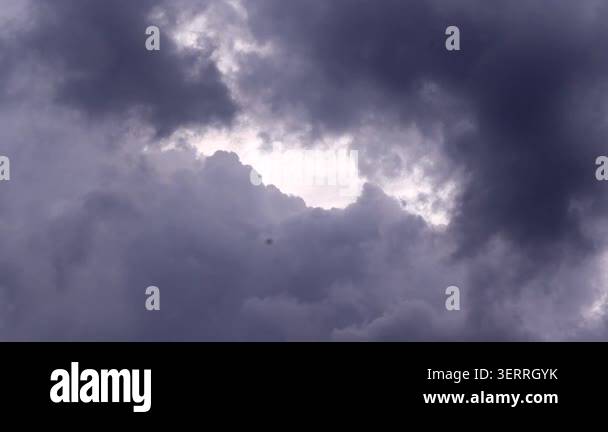 Dramatic dark storm clouds gathering in the sky as sunlight breaks ...