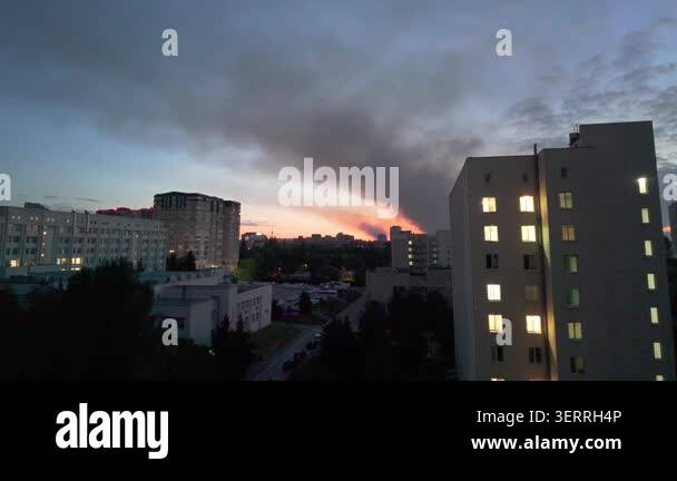 Wide angle static real time shot of a dark smoke plume expanding in the ...