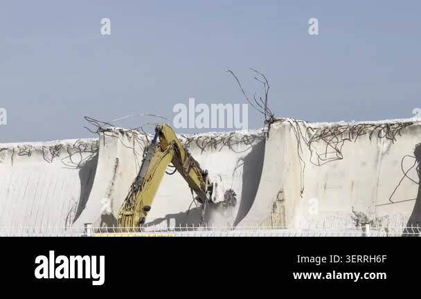A heavy-duty yellow excavator with a specialized cutting attachment ...
