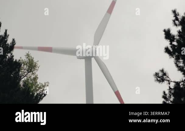 Low-angle view of a large wind turbine with its propeller blades ...