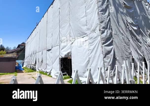 Tilting Shot of a Renovation Construction Site Covered in Sheets Under ...