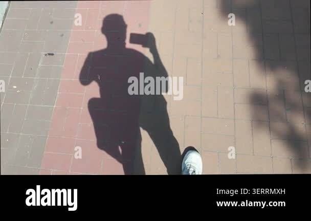A tourist taking photos of landmarks on a smartphone. Shadow ...