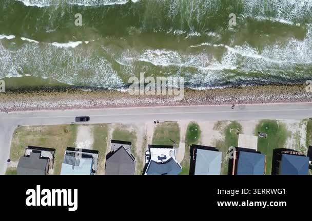 Seawall coastal band houses along Seashell Dr sit beside Gulf roadway ...