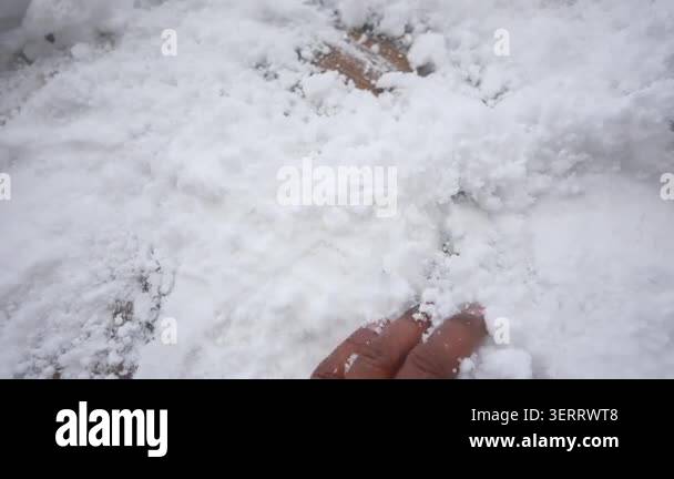 A hand is seen touching fresh snow on a surface outside in winter Stock ...