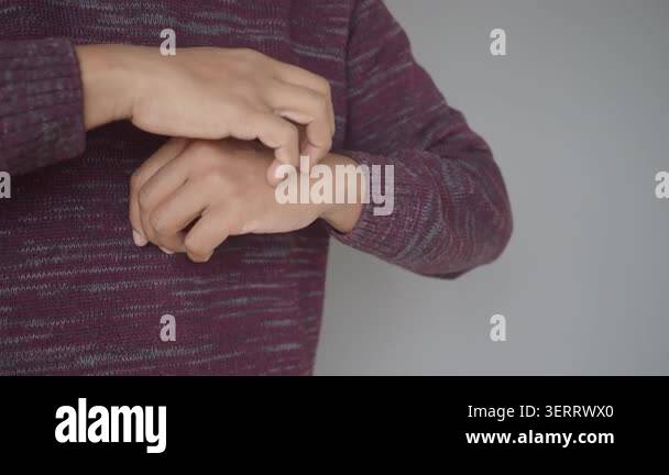 A man is scratching his arm while he stands still in a room Stock Video ...