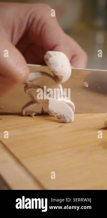 A hand is cutting mushrooms on a wooden board with a knife Stock Video ...