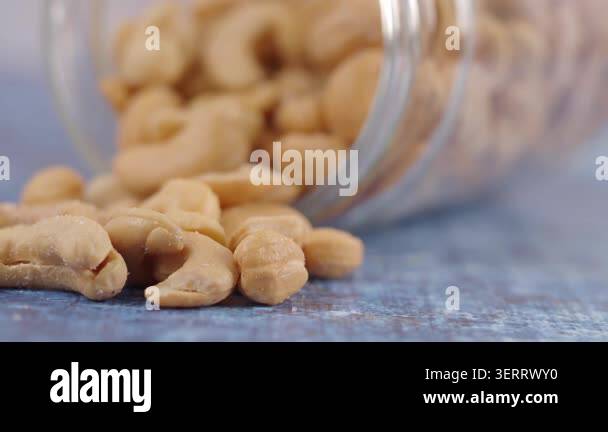 Cashews fall from a jar and scatter on a blue table Stock Video Footage ...