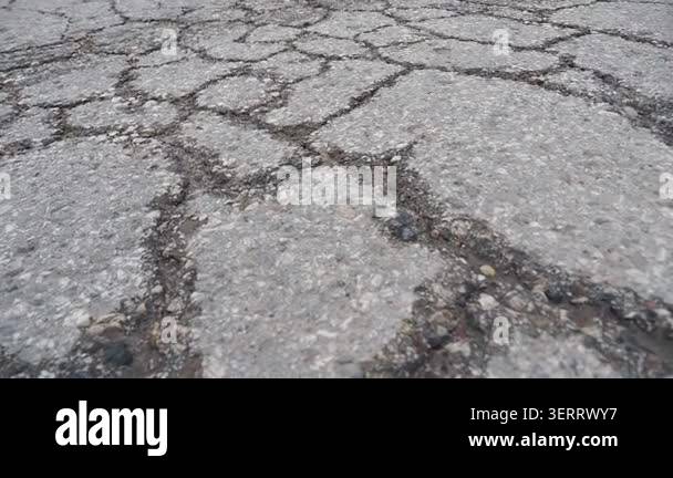 Close-up of cracked pavement in a city area shows wear and damage Stock ...