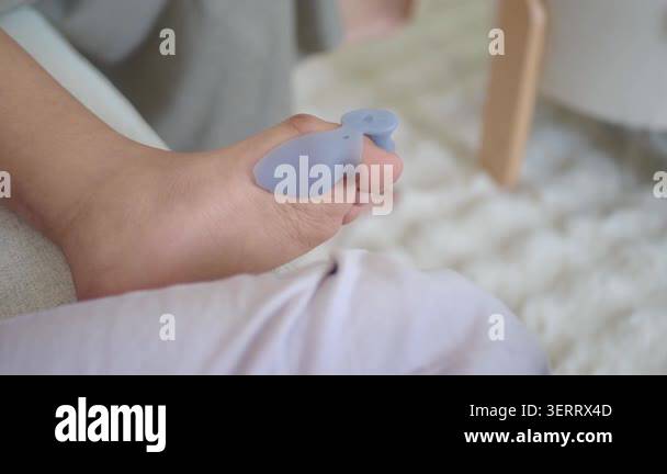 child uses a foot tool to care for dry skin on the foot at home Stock ...
