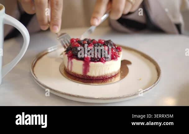 A person cuts a round dessert topped with berries in a cafe Stock Video ...