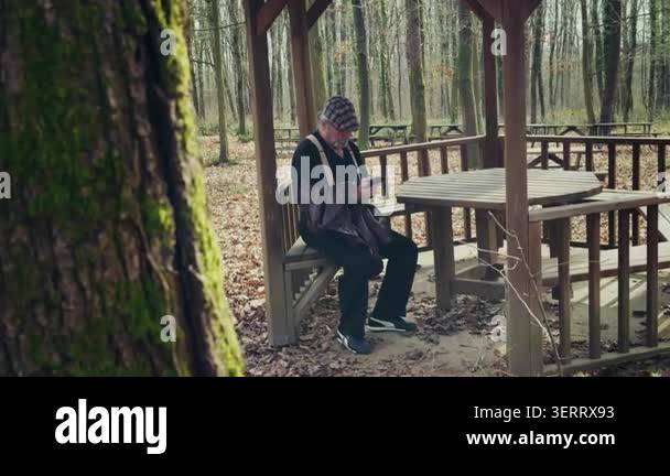 An Old Senior Man in a Hat Sitting on a Bench on a Nature Trip Stock ...