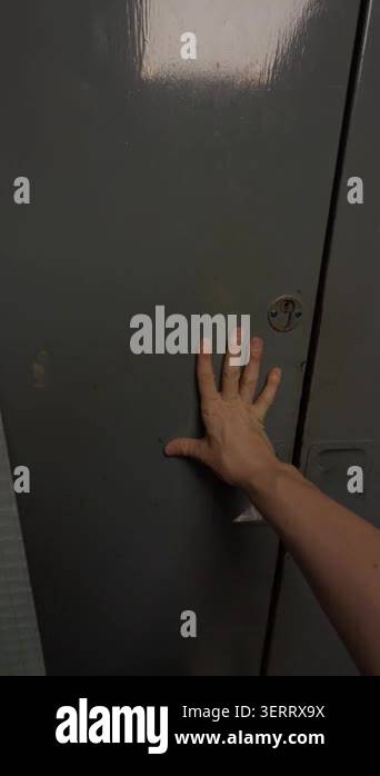 First-person perspective of a hand opening a gray metal door, revealing ...