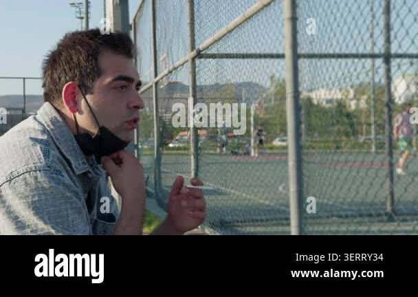 Man With Protection Mask In Basketball Court Outdoor Smokes Even Though ...