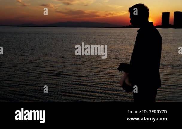 Man Silhouette Feeding Throwing Bread to the Fishes in Sunset Light ...