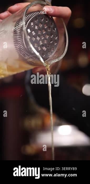 Bartender preparing a signature cocktail in a stylish moody bar Stock ...