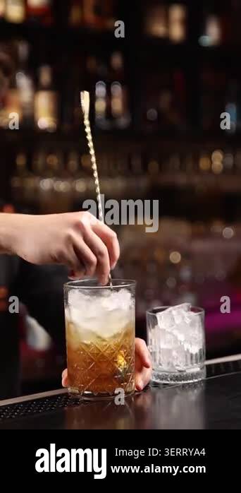 Bartender preparing a signature cocktail in a stylish moody bar Stock ...