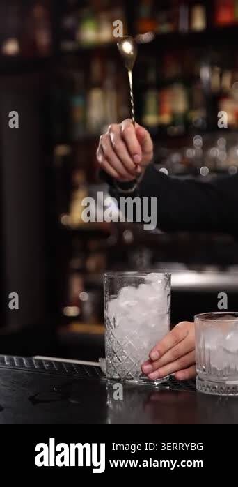 Bartender preparing a signature cocktail in a stylish moody bar Stock ...