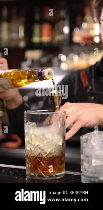 Bartender preparing a signature cocktail in a stylish moody bar Stock ...