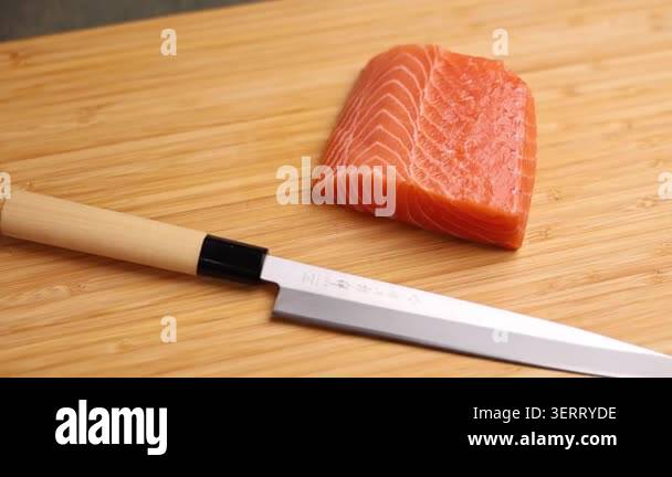 Close-up of a chef slicing fresh salmon on a wooden cutting board Stock ...