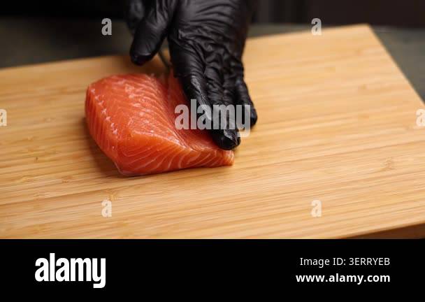 Close-up of a chef slicing fresh salmon on a wooden cutting board Stock ...