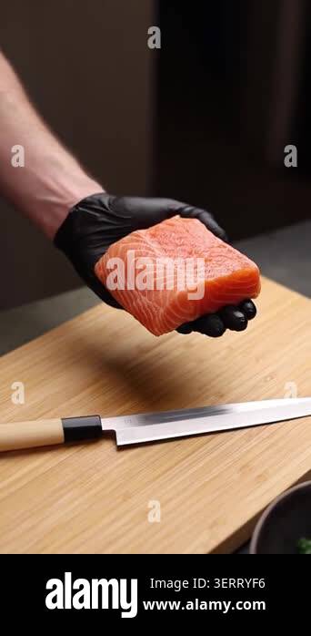 Close-up of a chef slicing fresh salmon on a wooden cutting board Stock ...