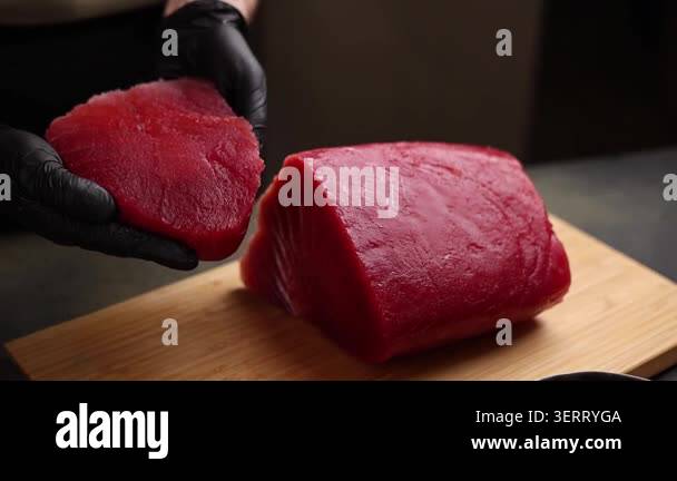 Close-up of a chef slicing fresh tuna on a wooden cutting board Stock ...