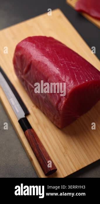 Close-up of a chef slicing fresh tuna on a wooden cutting board Stock ...