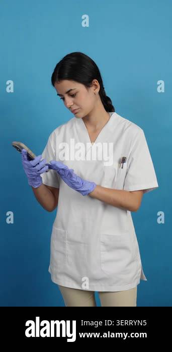 Female healthcare worker in uniform with protective gloves using a ...