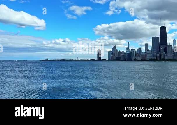 People can see the Chicago skyline while standing near the water. The ...