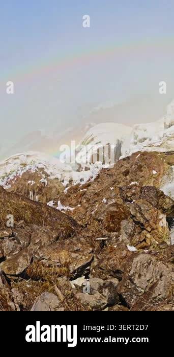 Snow and ice cover the mountain peaks in a high location. A faint ...