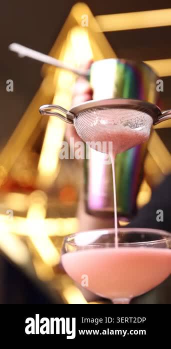 A bartender skillfully prepares a signature cocktail in a moody bar ...
