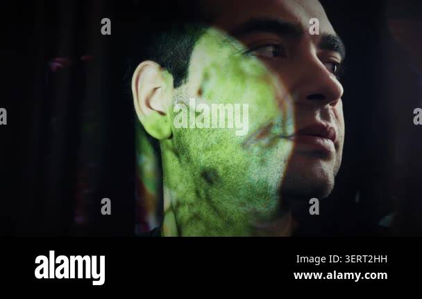 Cinematic portrait of a man illuminated by colorful light projections ...