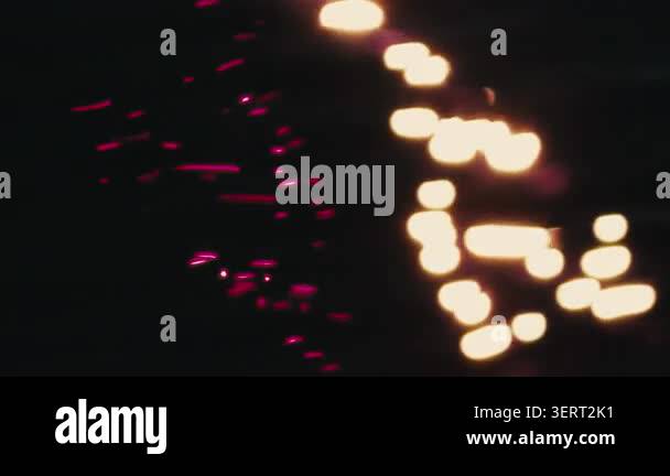 Abstract light bokeh streaks moving across a dark background, creating ...