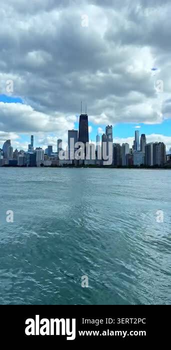 View of Chicago skyline with tall buildings and cloudy sky. Water ...