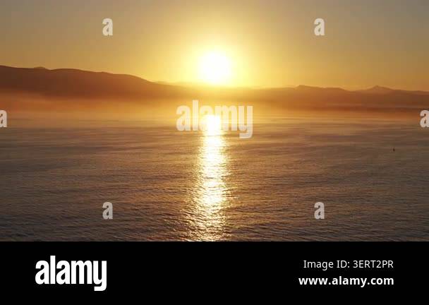 Golden sun path reflecting on calm ocean water at sunset copy space ...