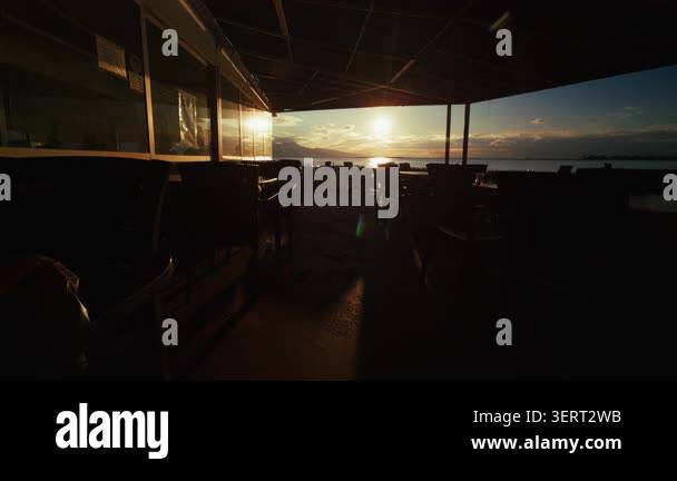 A quiet abandoned beachside cafe bathed in warm sunset light, with soft ...