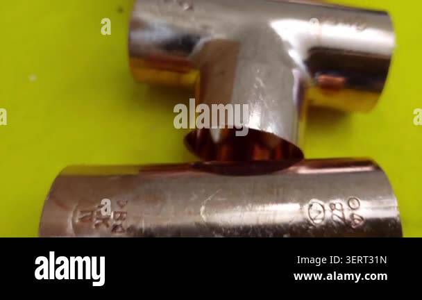 Copper pipe T-pieces fittings on yellow background Stock Video Footage ...