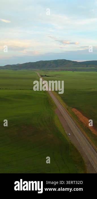 Vertical Screen: Aerial drone footage of a straight highway stretching ...