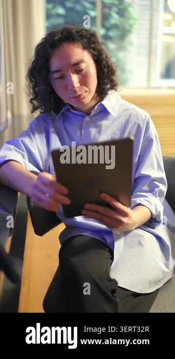 Professional person looks at a tablet with focused attention in a ...
