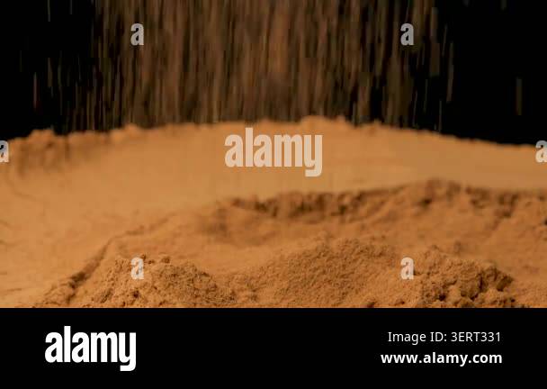 Cinematic sprinkle of raw cocoa powder on black background slow motion ...