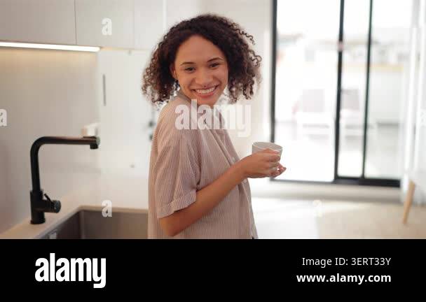 African American young woman with coffee in the morning enjoys a warm ...