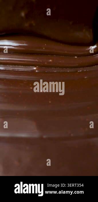 Slow motion vertical macro shot of melted dark chocolate flow Stock ...