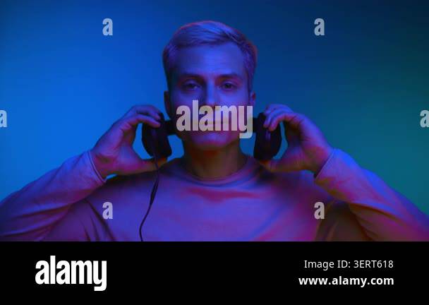 Portrait of Man Putting on Headphones and Listening Music Isolated in ...